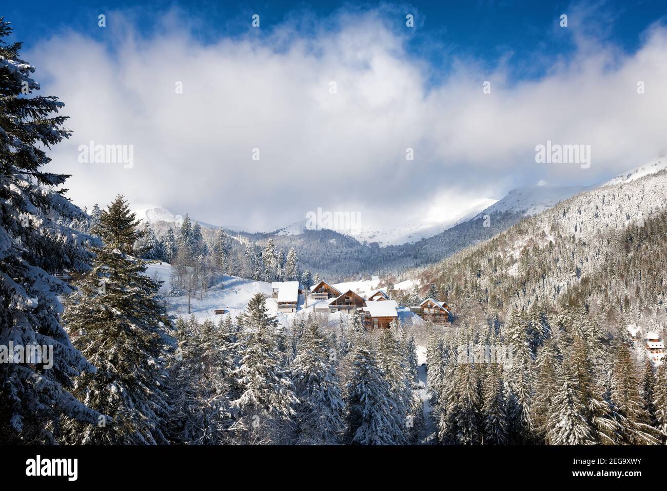 snowy chalets in a valley surronded by mountains, winter landscape ...