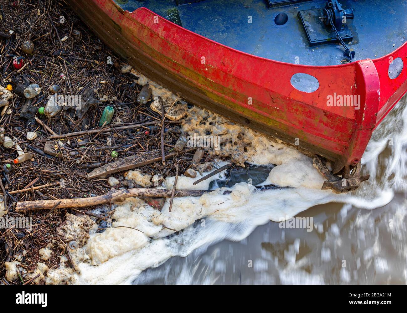 Plastic bottles and other toxic waste trapped by bow of boat in fast ...