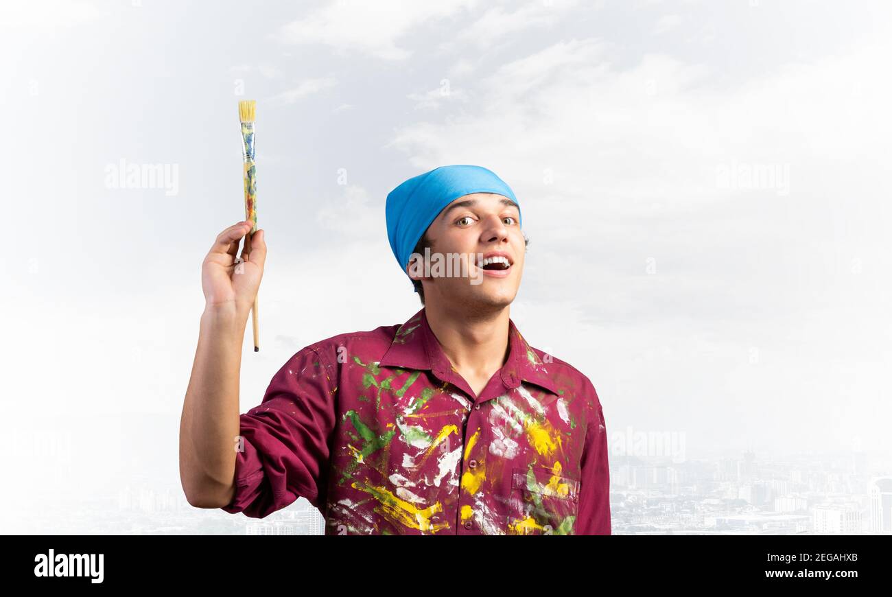 Smiling young painter artist pointing upwards Stock Photo - Alamy