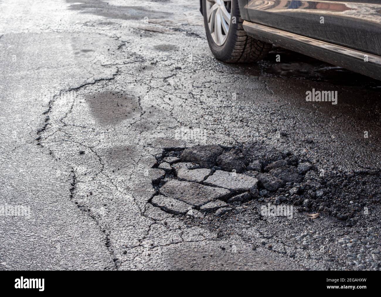 Pothole on a road in spring Stock Photo - Alamy