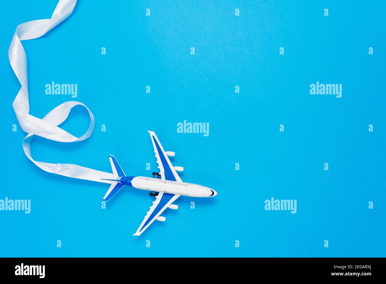 Flat lay design of travel concept with plane on blue background with ...