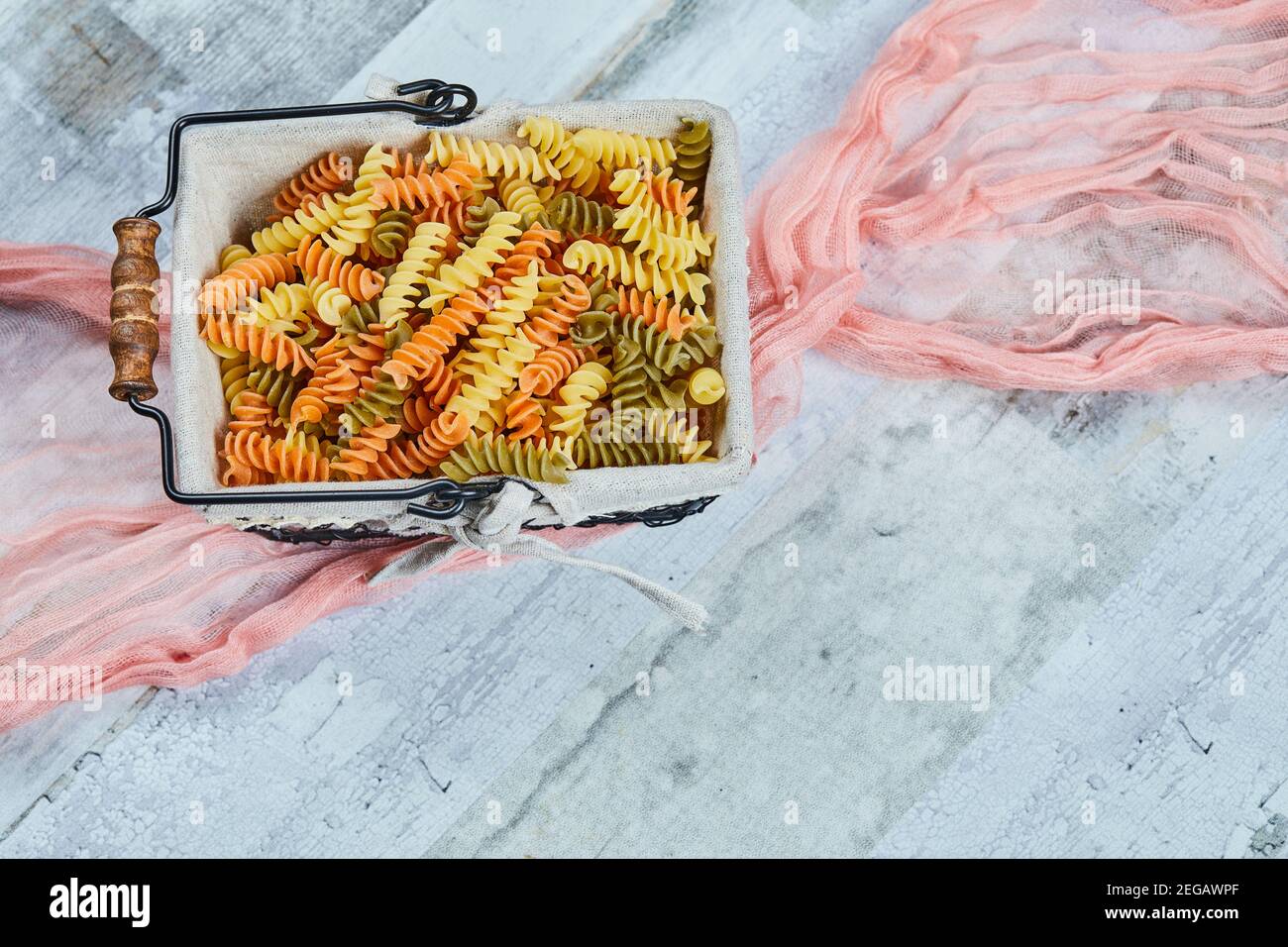 Colorful uncooked pasta on a blue background with pink tablecloth Stock ...