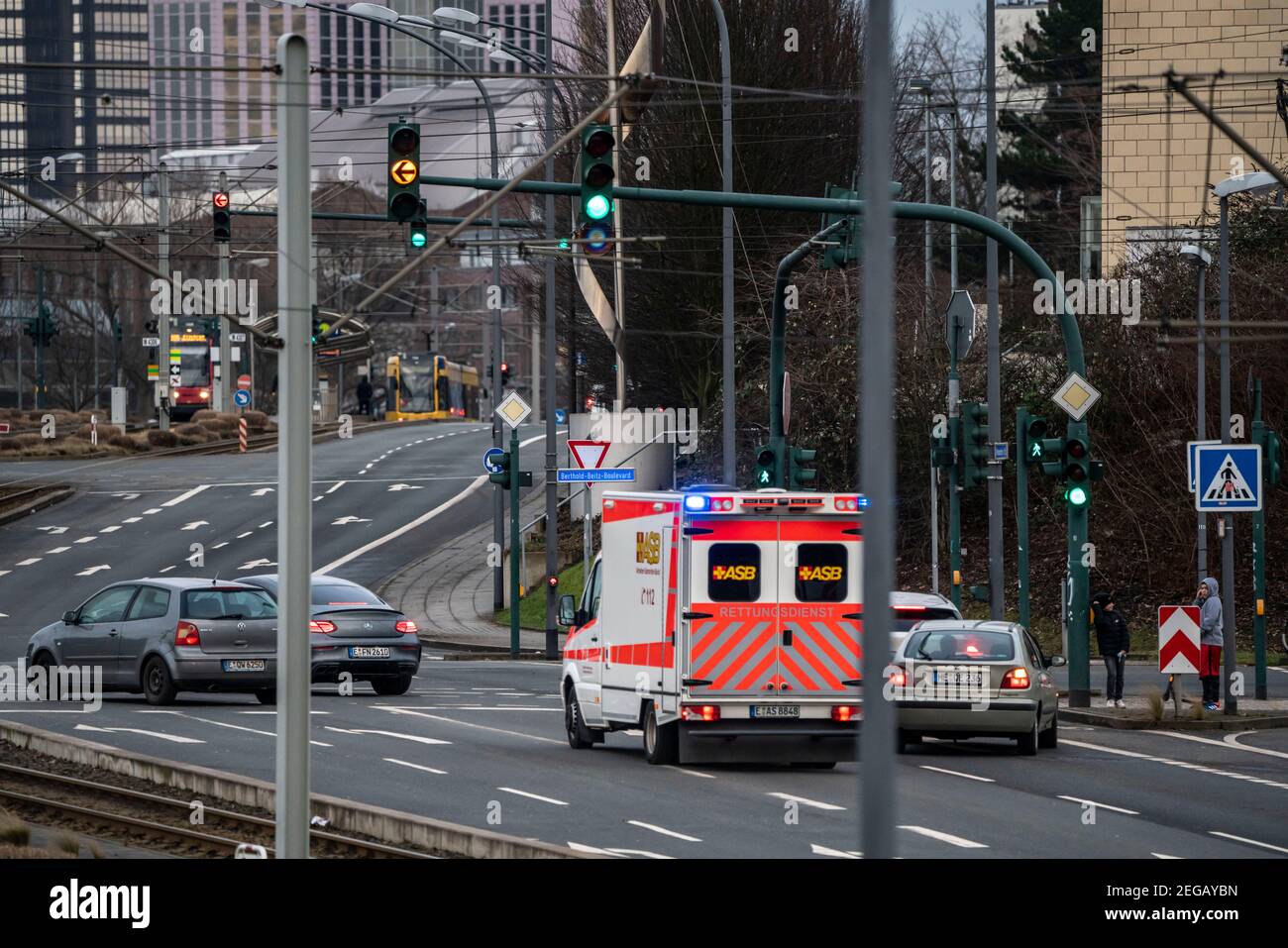 Ambulance on duty with blue light and siren, at a traffic light ...