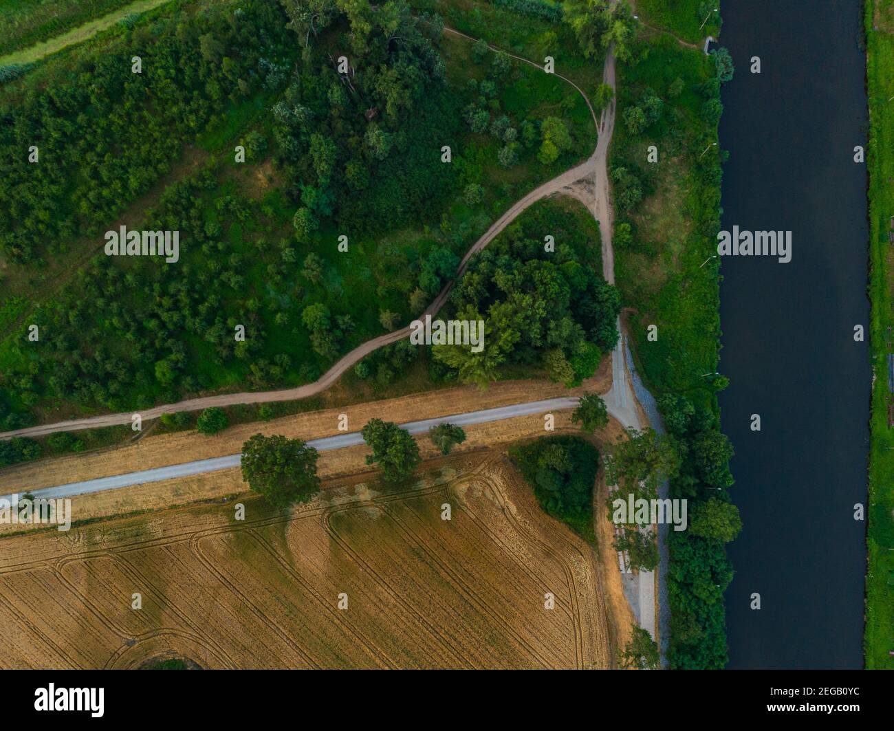 Aerial top down look to streets and paths between forest and fields and ...