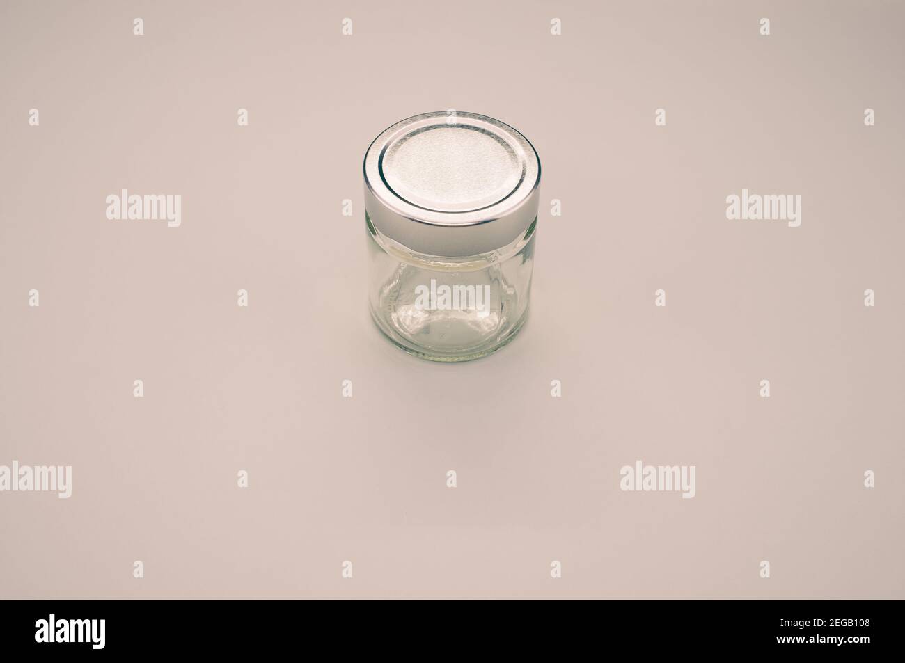 Top view of an empty glass jar with a silver lid isolated on gray ...