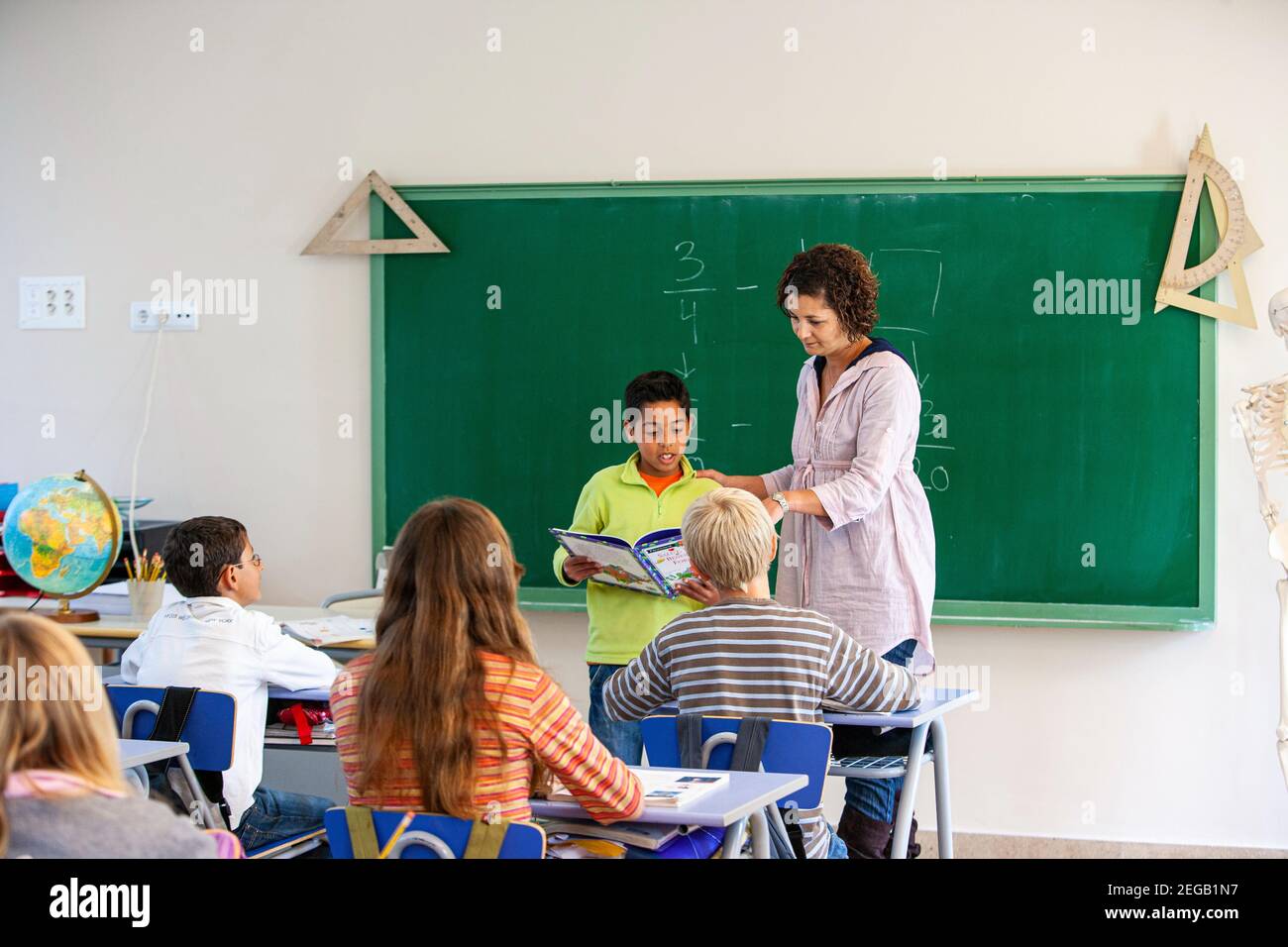 Teacher teaching her class in a school classroom Stock Photo - Alamy