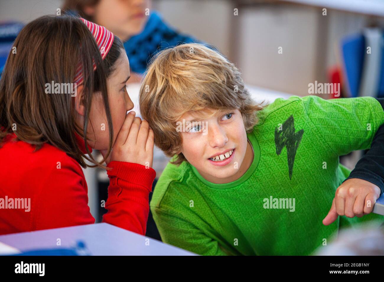 Young children whispering in a school classroom Stock Photo - Alamy