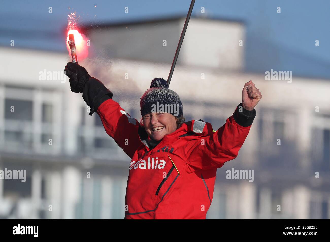 Pip Hare holds a flare as she sails her boat Medallia into Poole ...