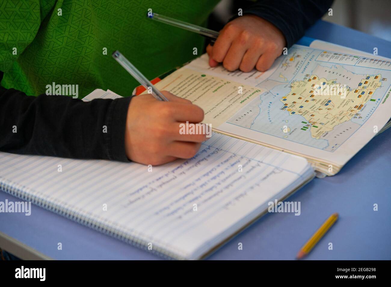 Young boy writing in school classroom Stock Photo - Alamy