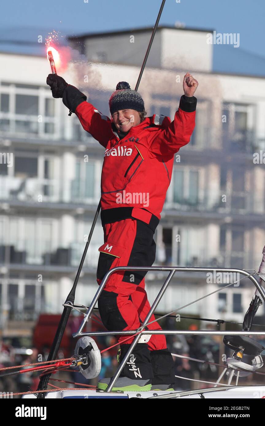 Pip Hare holds a flare as she sails her boat Medallia into Poole ...