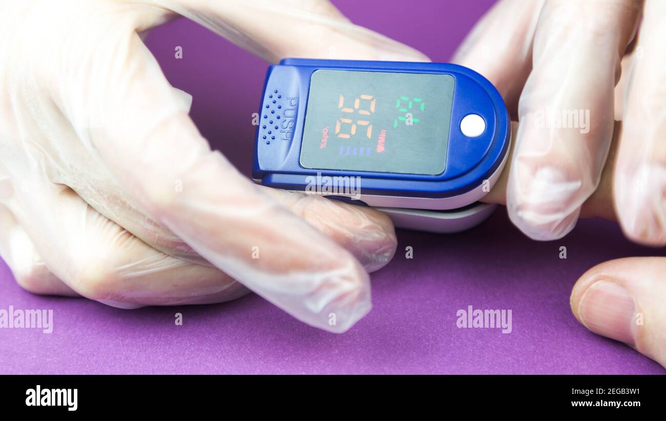 A doctor wearing gloves measures the oxygen level in blood. Close-up ...