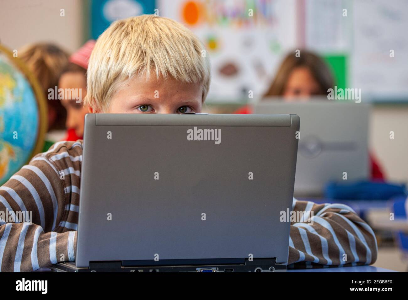 Young boy studying on a laptop in a school classroom Stock Photo - Alamy