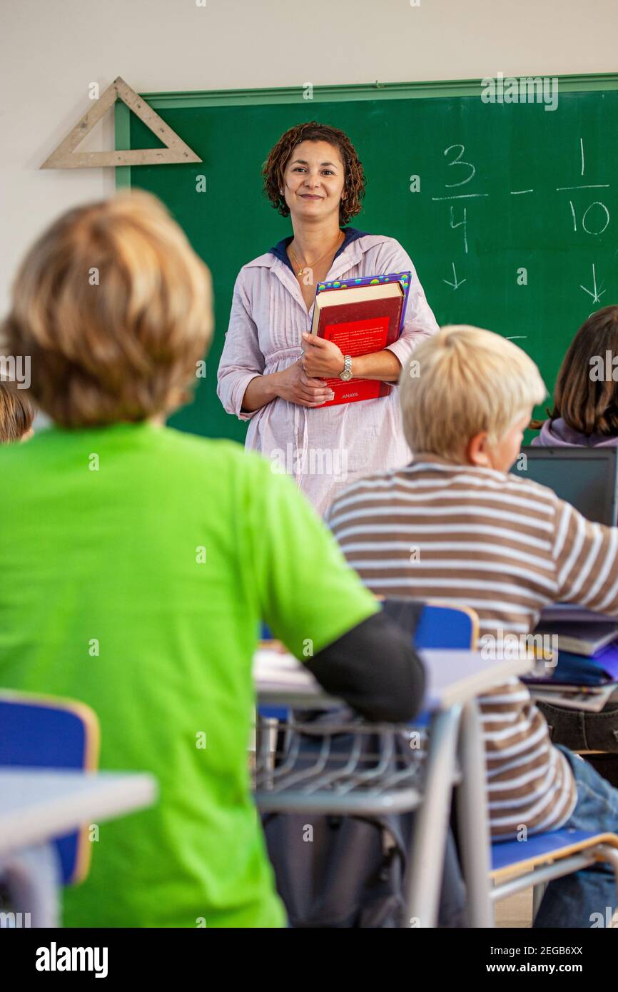 Teacher teaching her class in a school classroom Stock Photo - Alamy