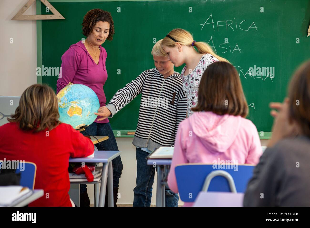 Teacher teaching her class in a school classroom Stock Photo - Alamy