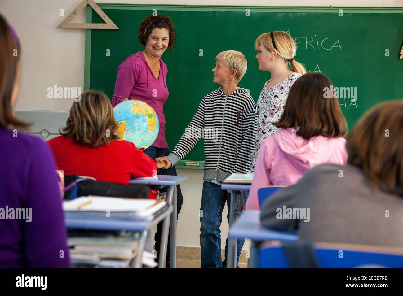 Teacher teaching her class in a school classroom Stock Photo - Alamy