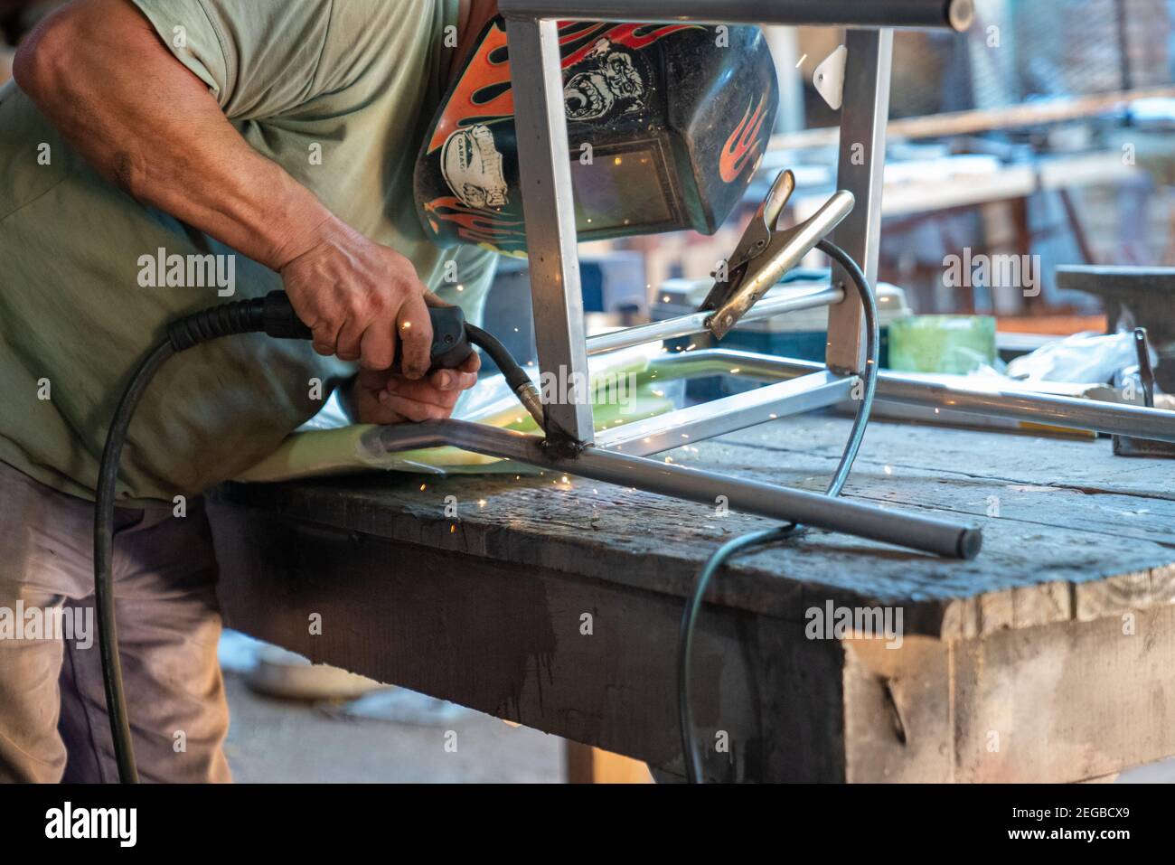 a man hand-welding a metal chair in his metallurgical workshop Stock ...