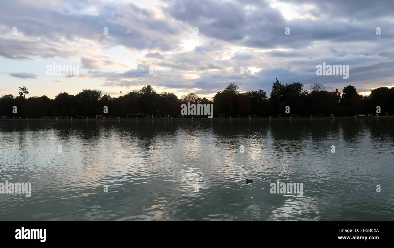 Trees and clouds reflecting in the water in Buen Retiro Park Madrid ...