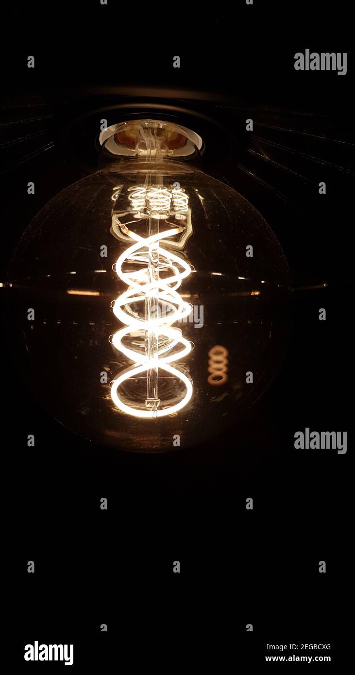 Shot of a classic Edison lightbulb on dark background with space for ...