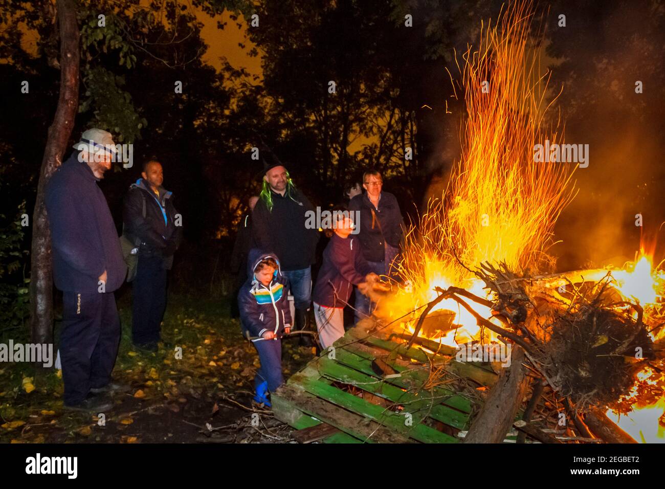 People standing around a bonfire in Sunnyside Gardens, a community ...