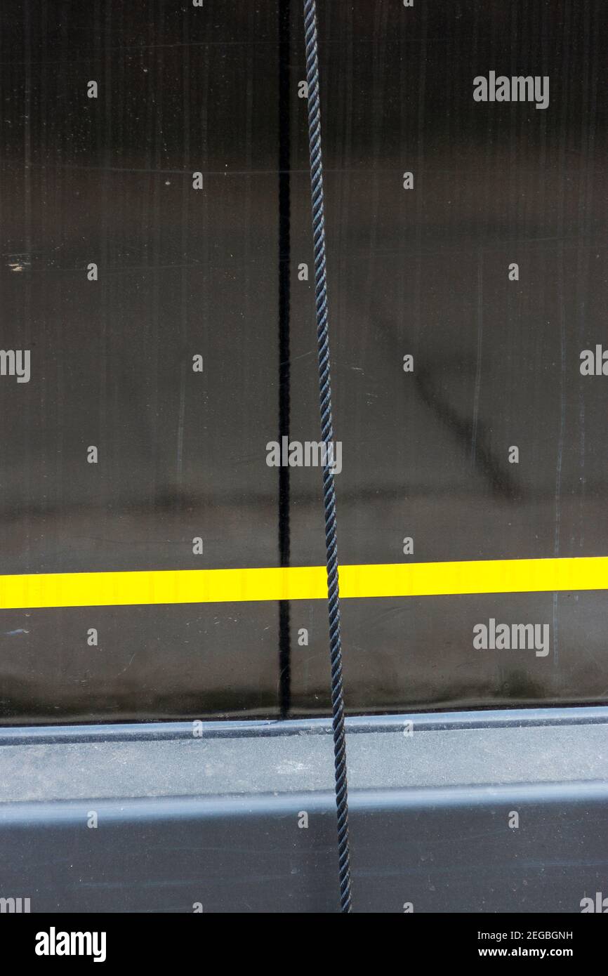 Abstract composition of a rope hanging from the side of a canal ...