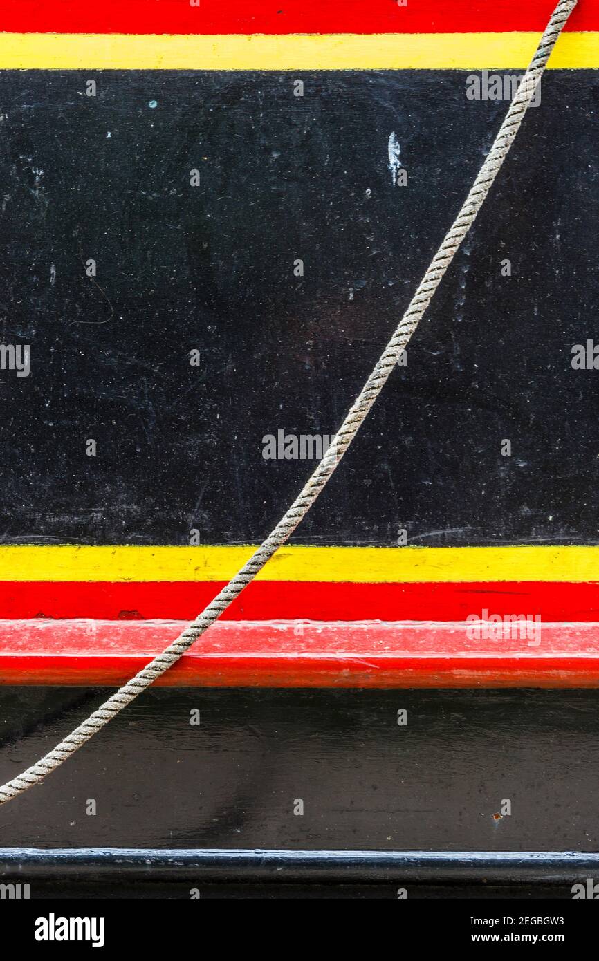 Abstract composition of a rope hanging from the side of a canal ...