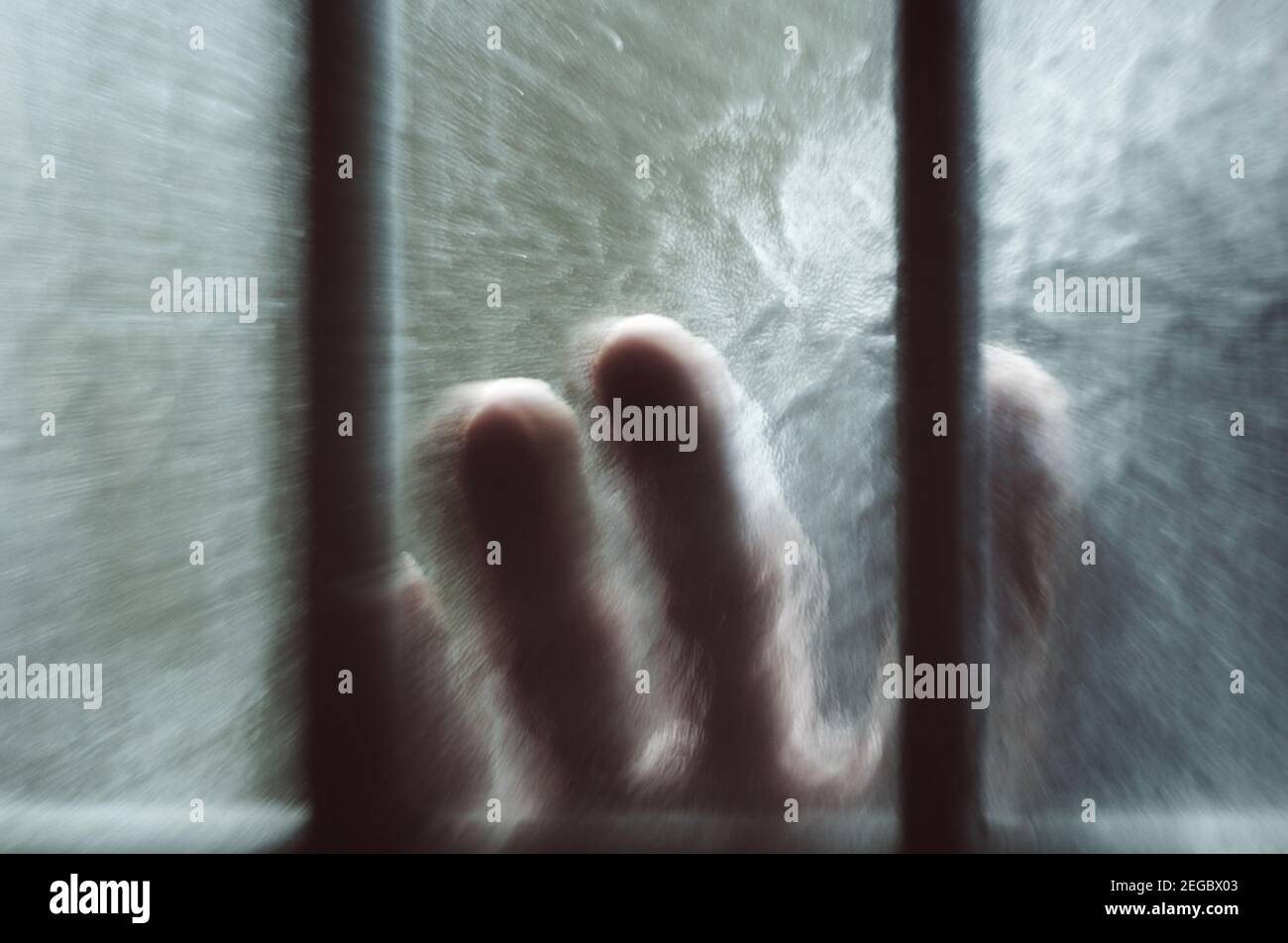 human fingers behind glass window with bars Stock Photo - Alamy
