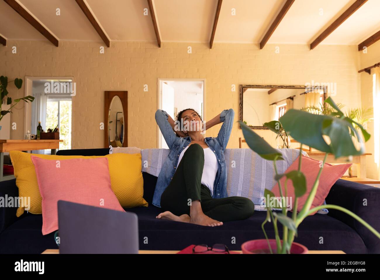 Caucasian woman stretching, sitting on sofa and relaxing at home Stock ...