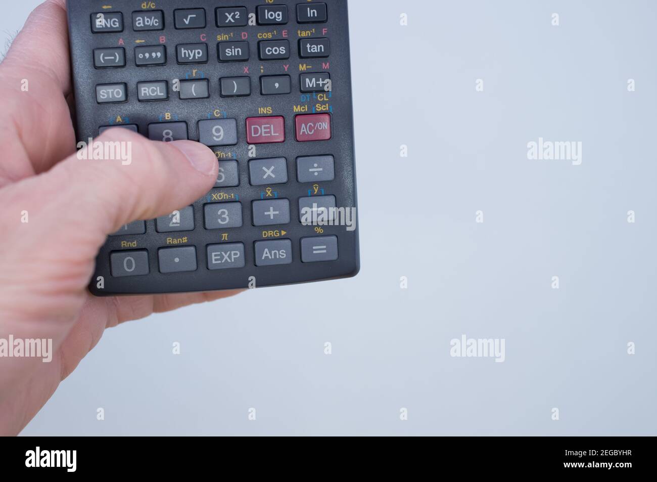 Closeup shot of a hand holding scientific calculator isolated on white ...