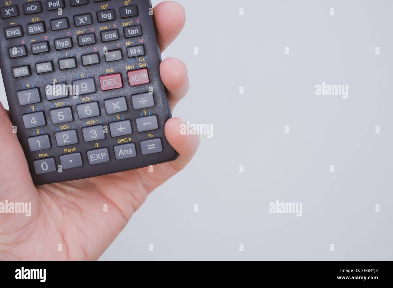 Closeup shot of a hand holding scientific calculator isolated on white ...