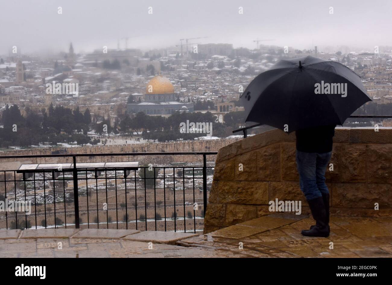 Jerusalem, Israel. 18th Feb, 2021. A man looks at snow on the Dome of ...