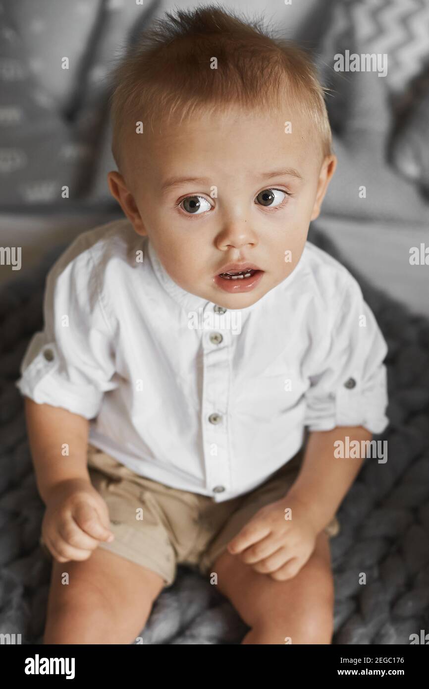 Little boy kid in a white shirt and beige shorts smiling and looking ...