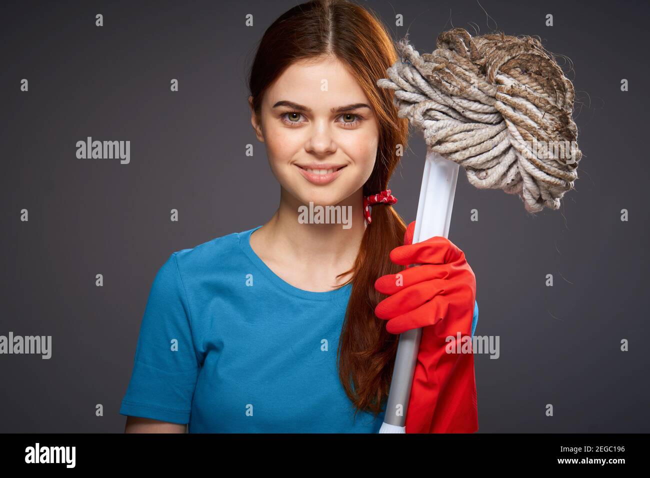 cleaning lady in a blue t-shirt holds a mop in her hand housekeeping ...