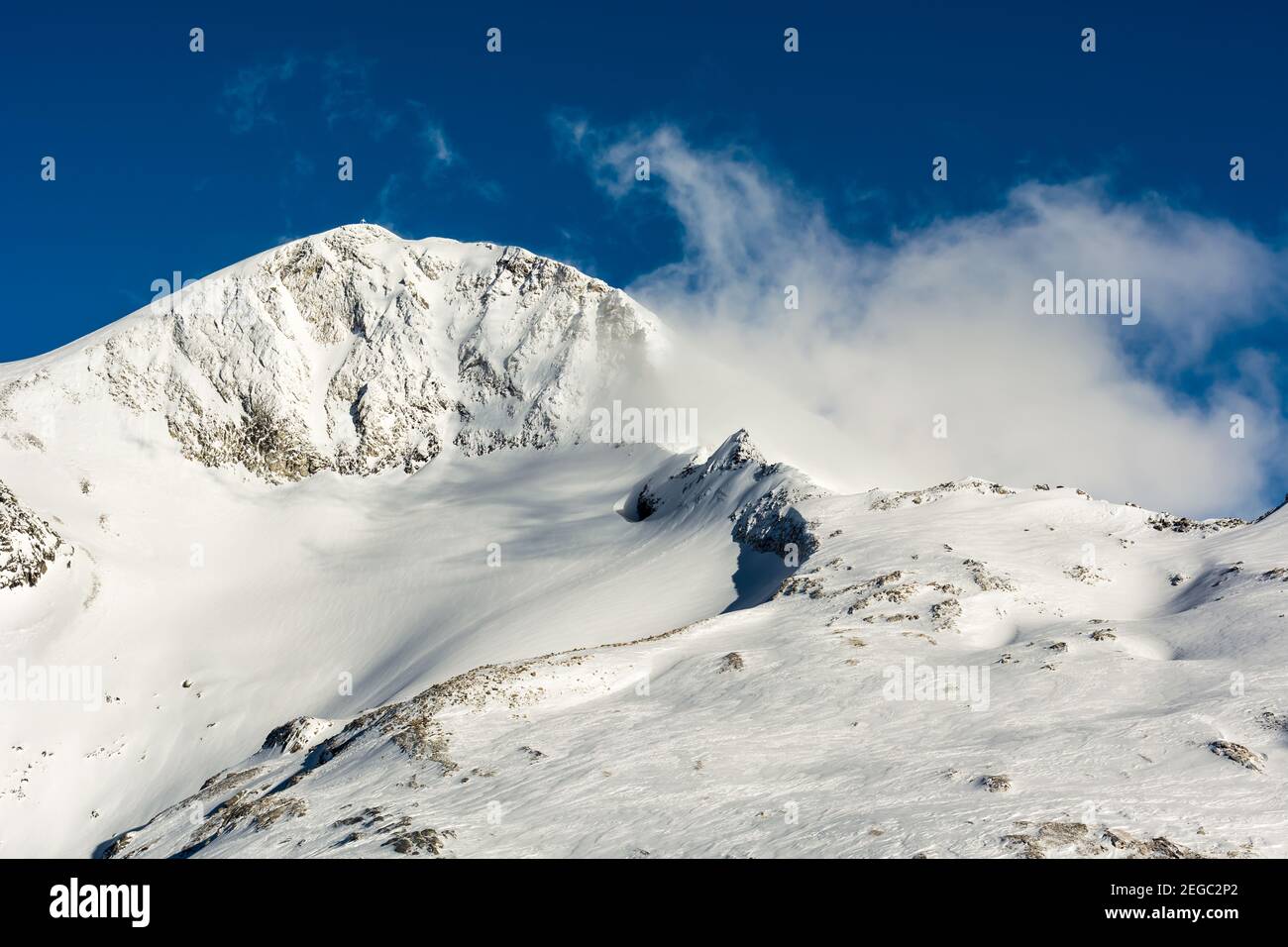 Sun rays falling on snow-covered mountains on a winter day Stock Photo ...