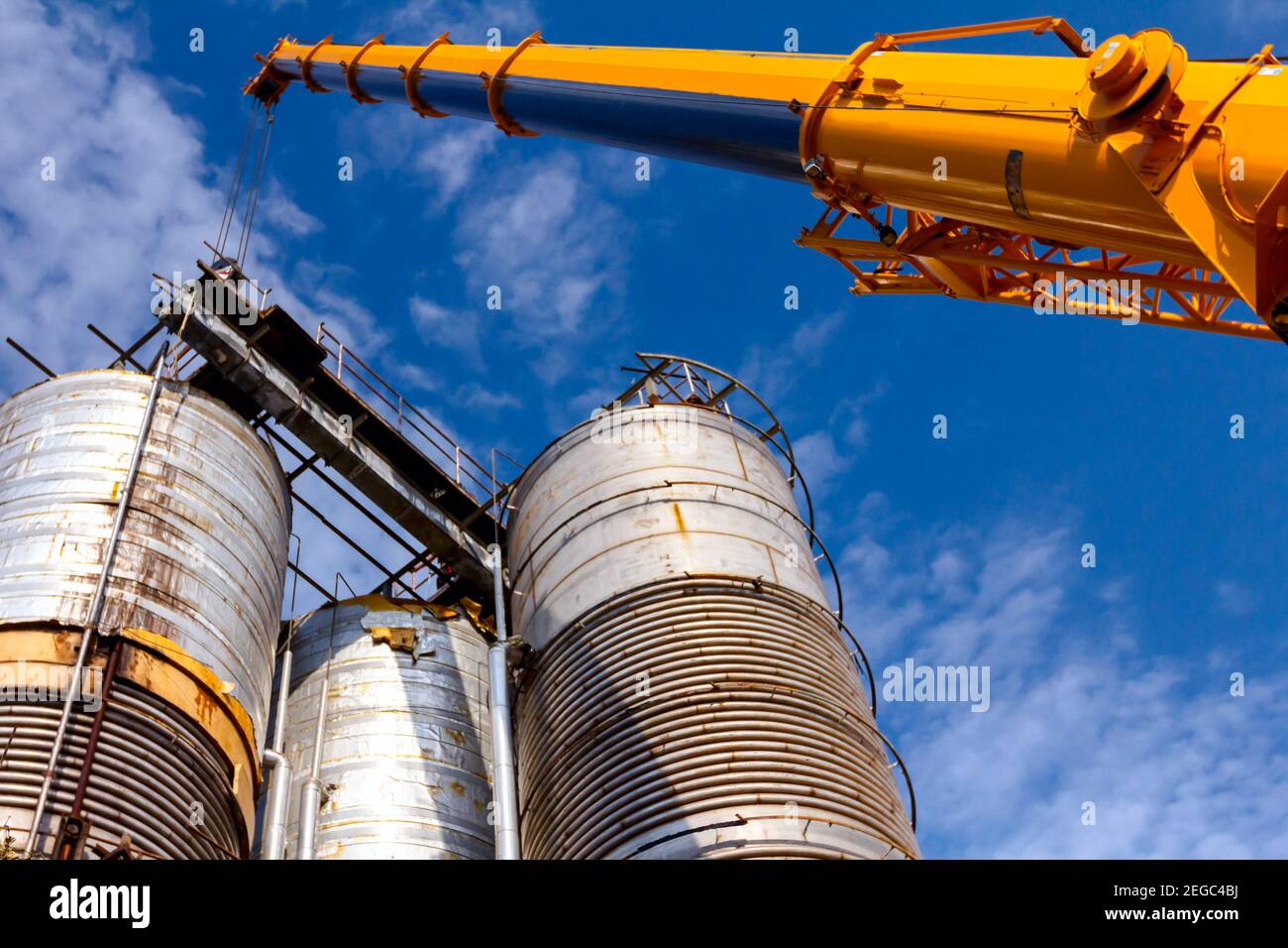 Crane is carry and keeps balance with heavy metal silo in industrial ...