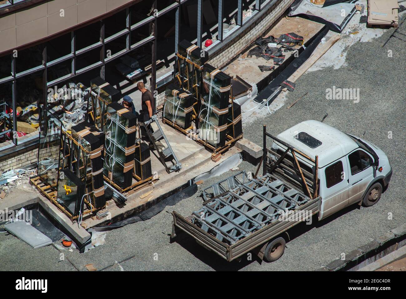 Window workers on a scaffold in construction yard on a building facade ...