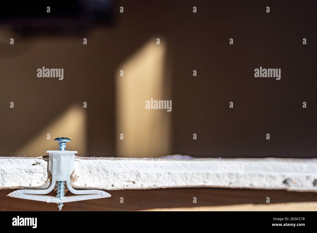 Side view of a drywall mount anchor and screw for hanging objects on ...