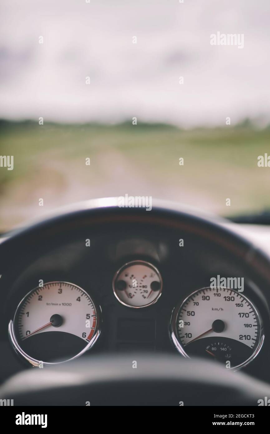 Car cockpit and a dirt road in the field. First person perspective ...