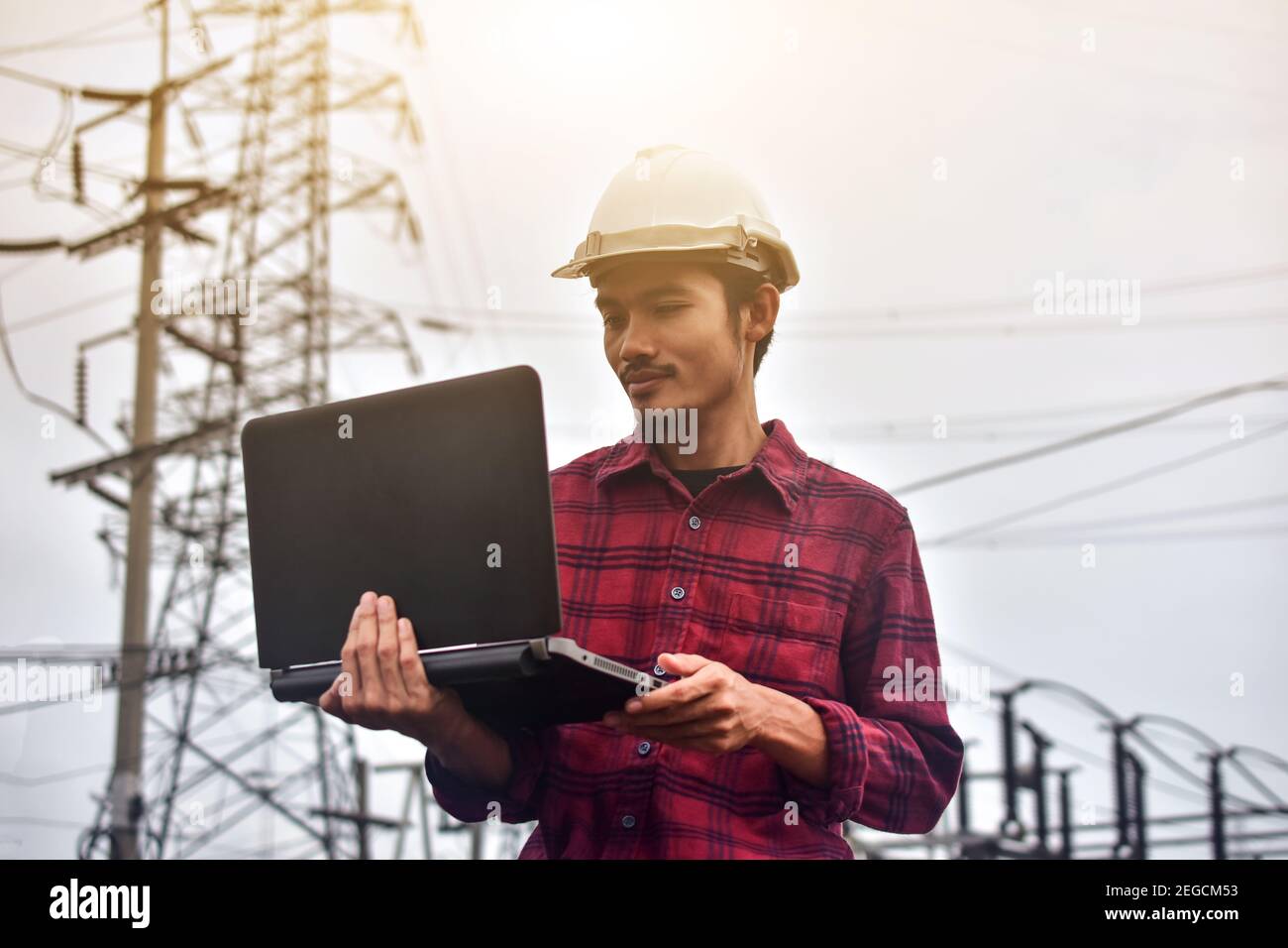 Engineer hold laptop computer inspection on site power plant high volte ...
