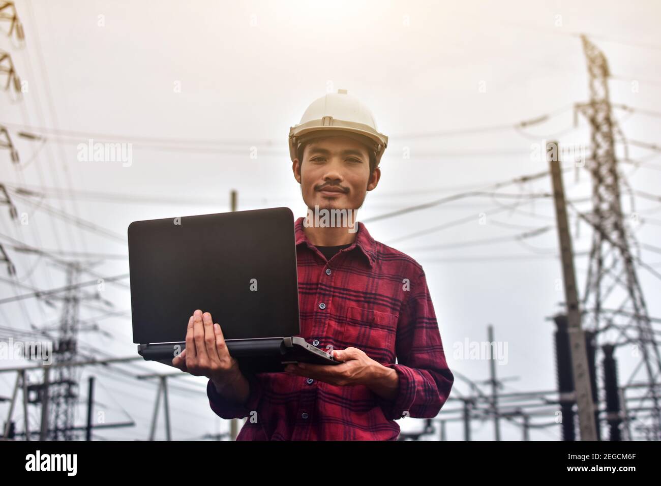 Engineer hold laptop computer inspection on site power plant high volte ...