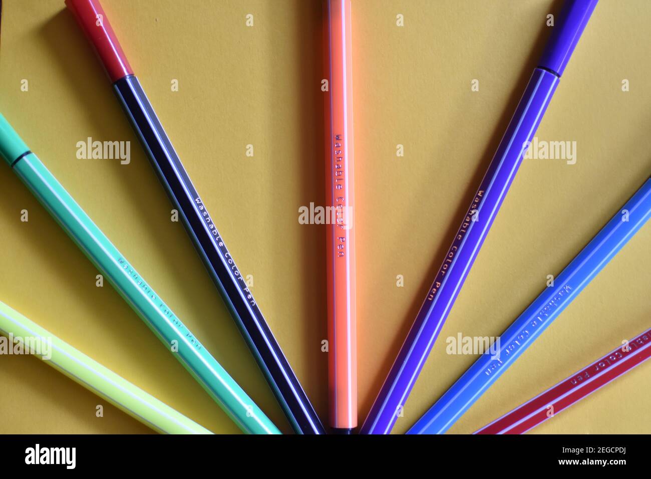 colored markers on yellow background Stock Photo - Alamy