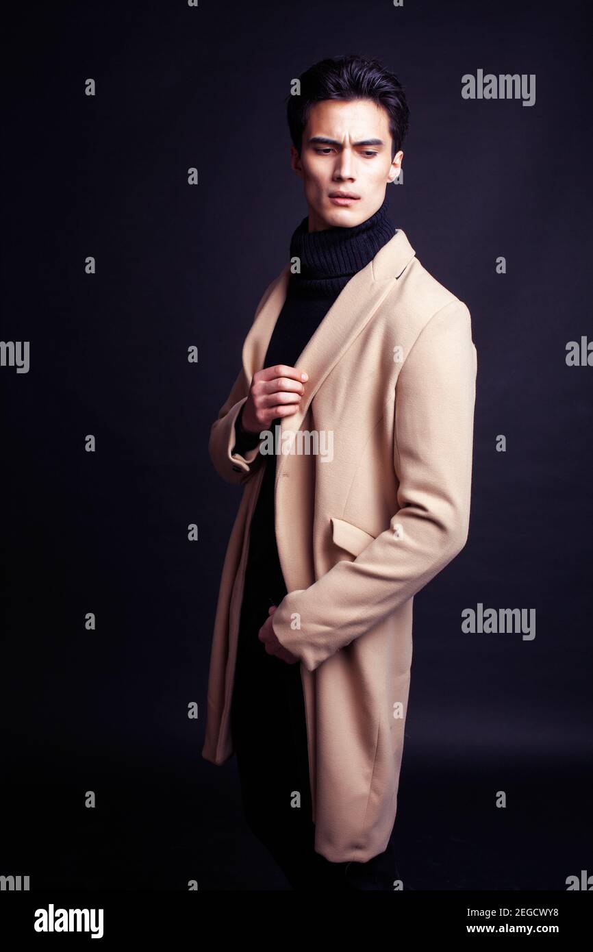 handsome asian fashion looking man posing in studio on black background ...