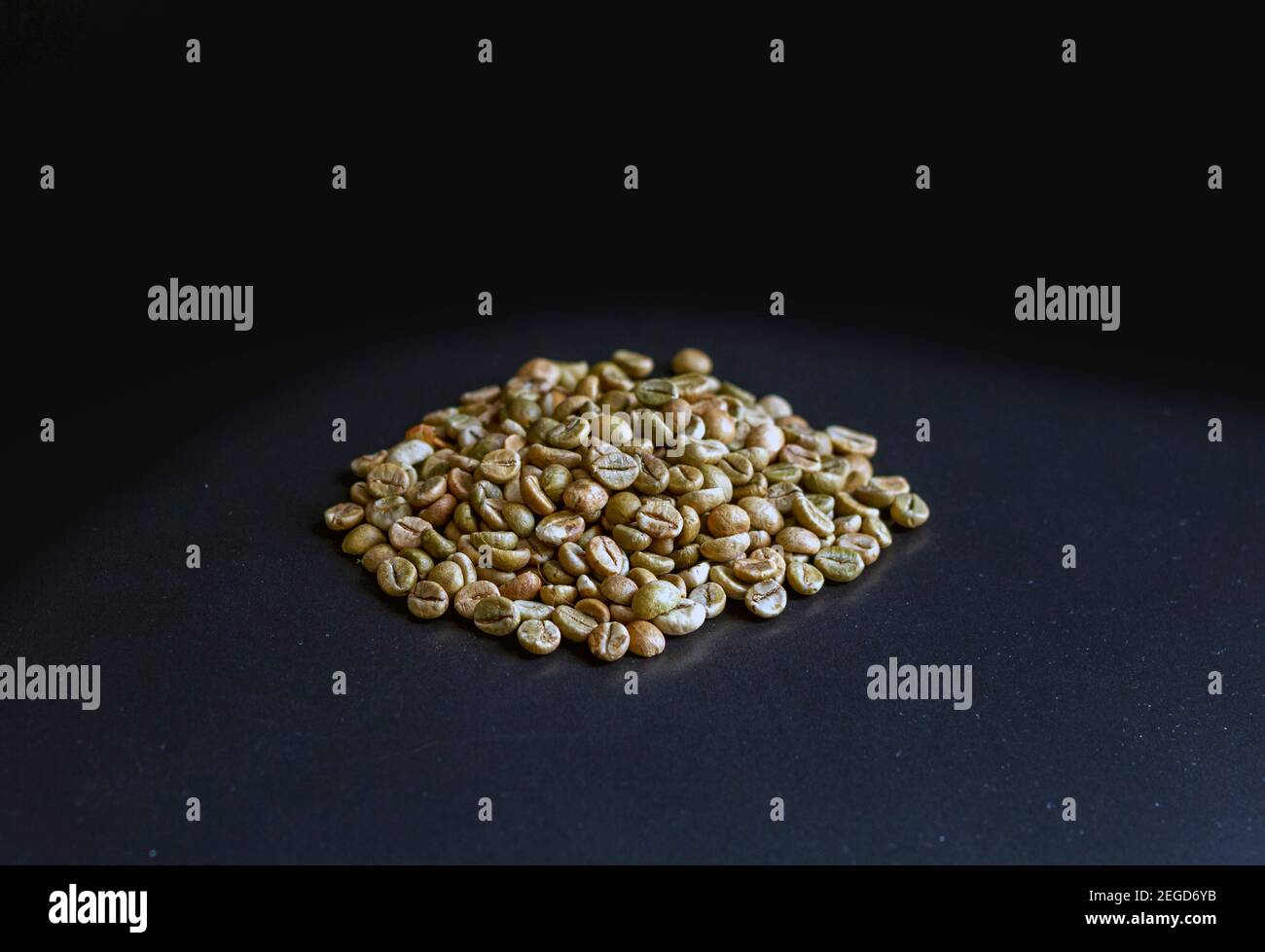 Unroasted coffee beans of the Robusta variety on a black background ...