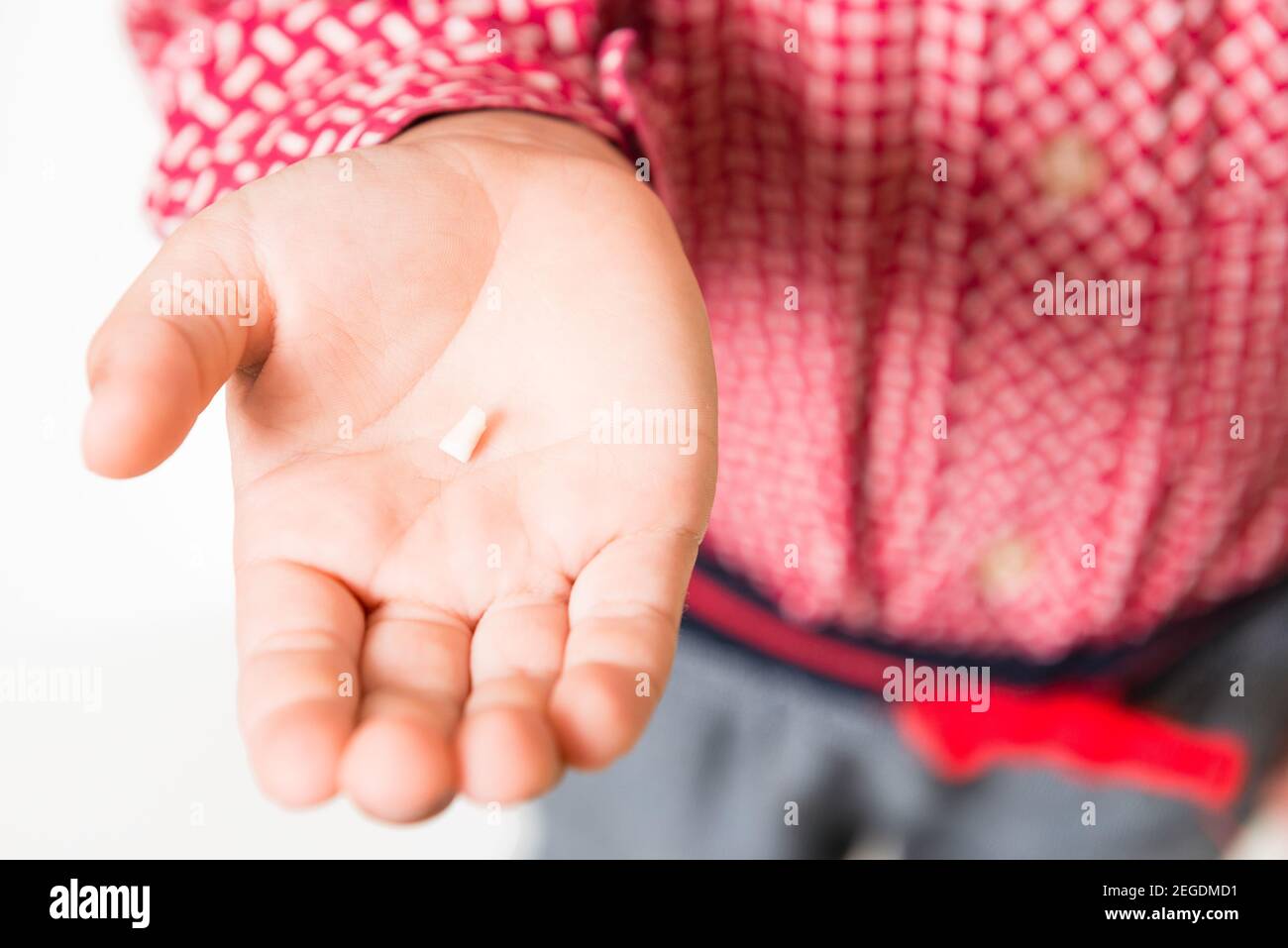 Milk-tooth in hand of kid, isolated on white background Stock Photo - Alamy
