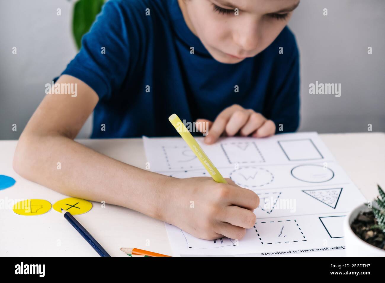 Boy focusing on his homework while sitting at desk Stock Photo - Alamy