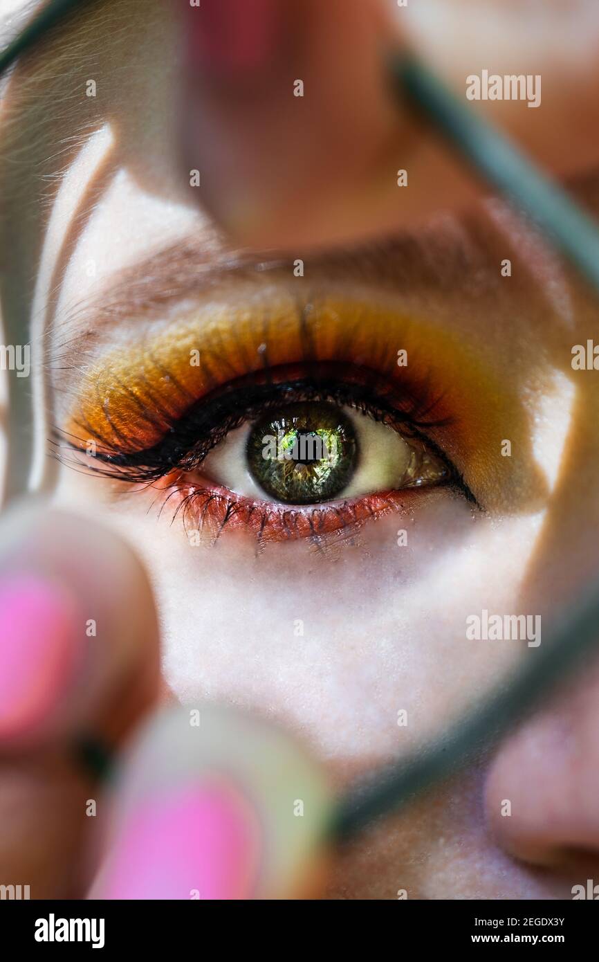Female eyes looking through fence hi-res stock photography and images ...