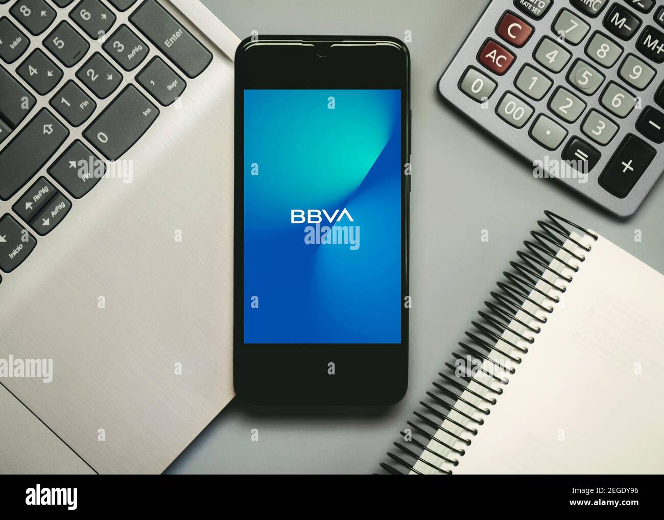 BBVA mobile app logo on smartphone screen next to a notebook, laptop ...