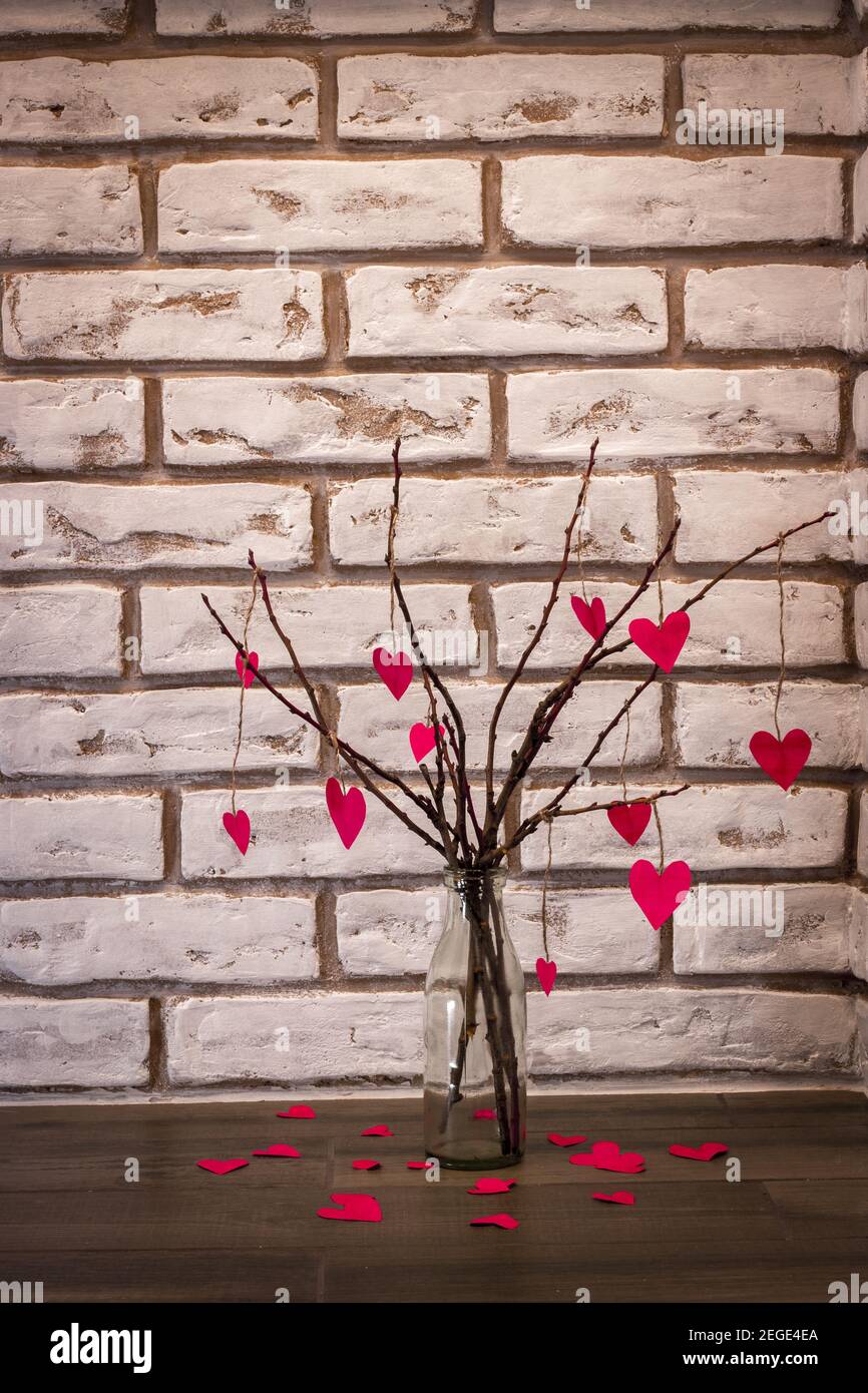 Bouquet of branches and fallen hearts on white brick wall background ...