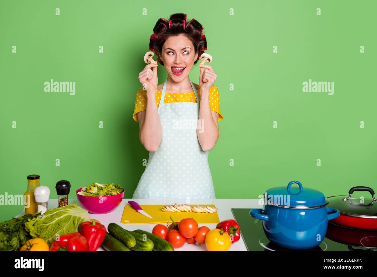 Excited girl hair rollers prepare veggie recipe fresh organic supper ...
