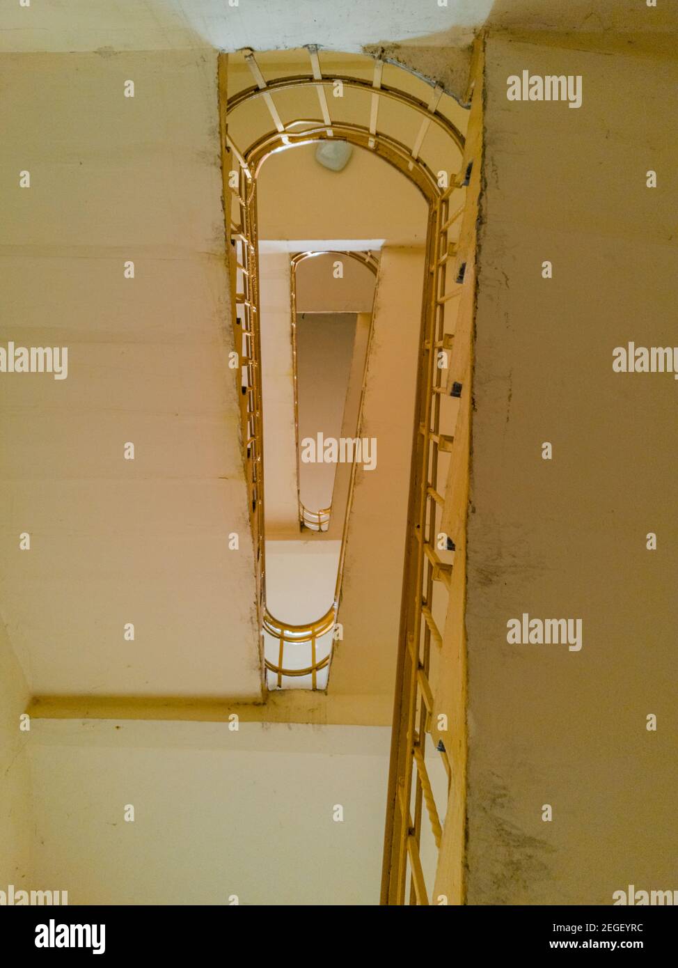 Upward view to spiral staircase with yellow railing Stock Photo - Alamy