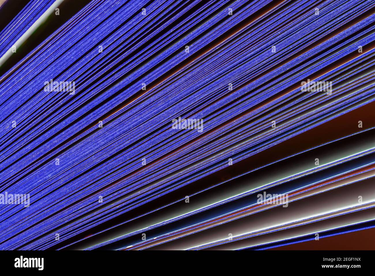 Butt end of open pages of book painted in blue. Bright background ...